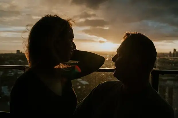 Steph in Rob stojita na balkonu svojega stanovanja na zahajajočem soncu. Foto: James Day.