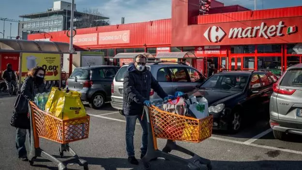 Personas con carros de comestibles en un supermercado de Milán