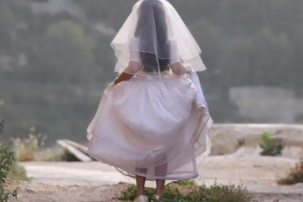 Tampilan mburi bocah wadon remaja nganggo gaun pengantin